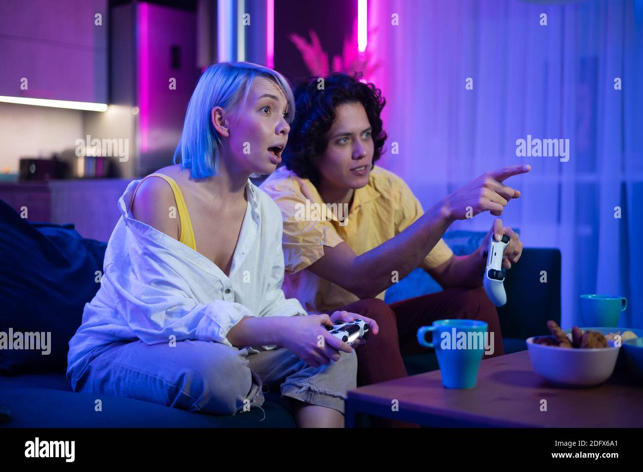 Happy boyfriend and girlfriend playing video games and holding ...