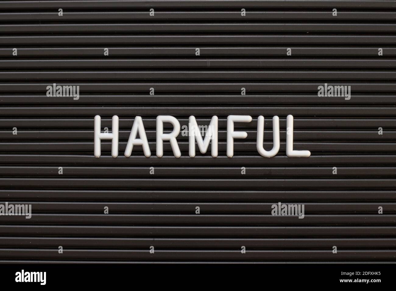 White alphabet in word harmful on black color felt letter board ...