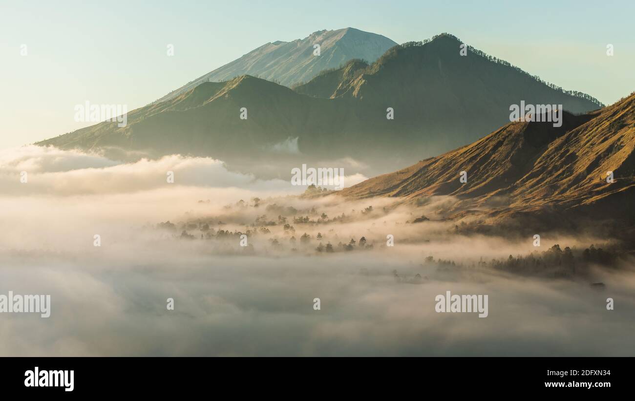Sunrise view of mount Batur, Abang and Agung volcano in Bali from ...