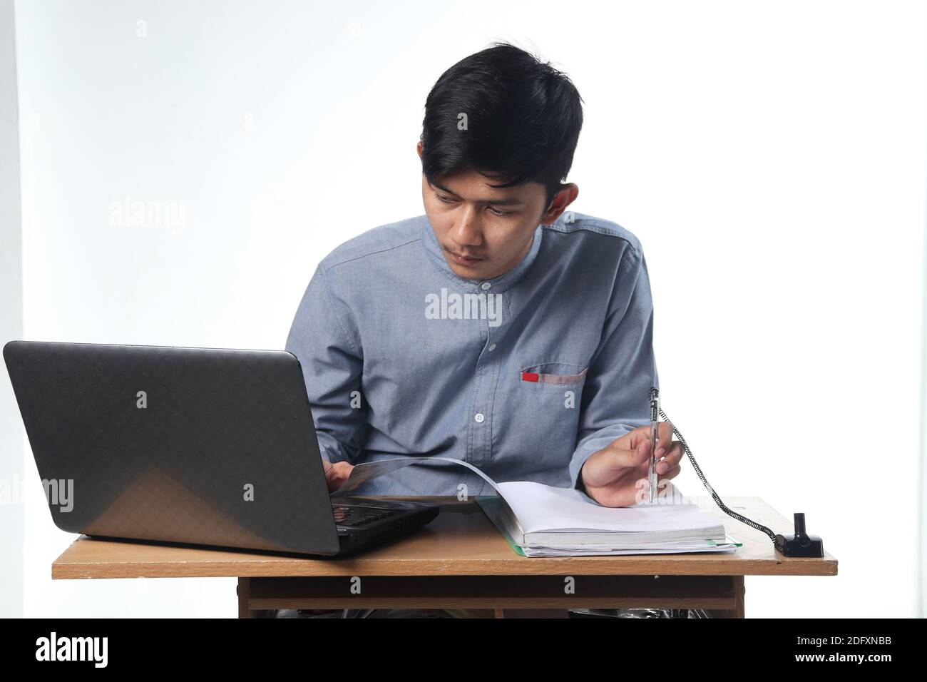portraits of Asian men seriously working on reports on computers and ...