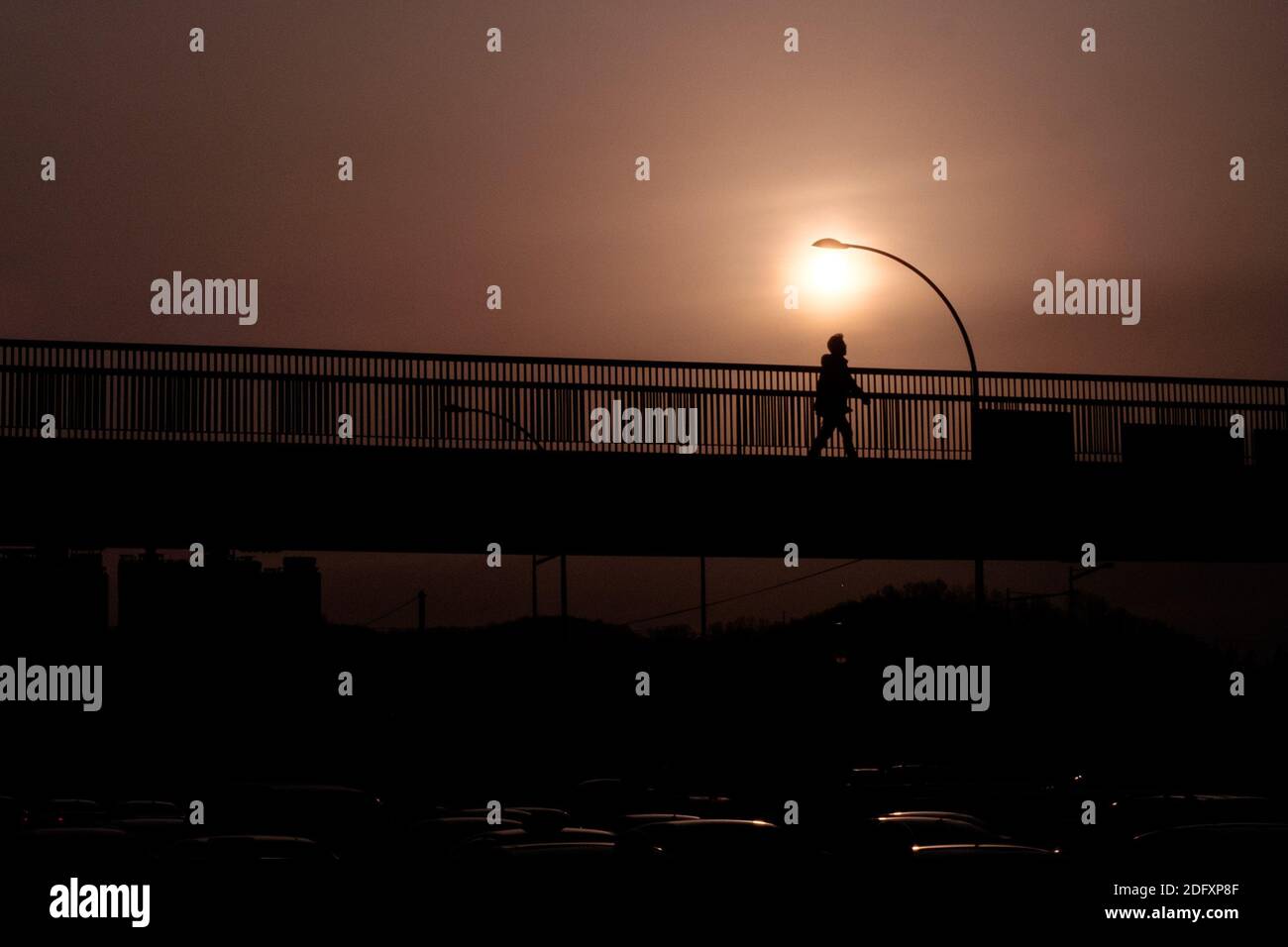 man walking under sunset Stock Photo - Alamy