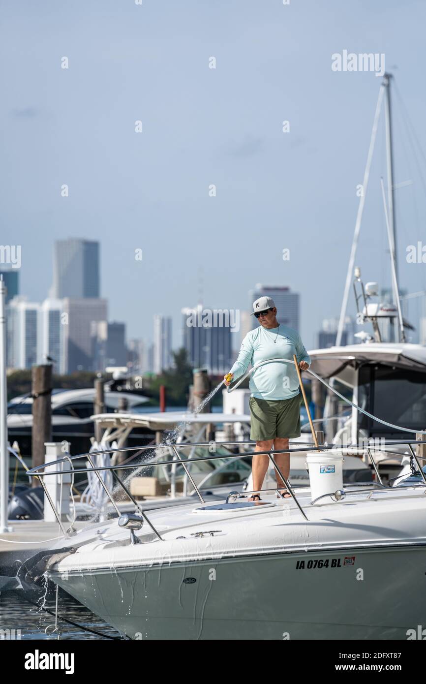 Street photography woman washing her boat at a marina Stock Photo - Alamy