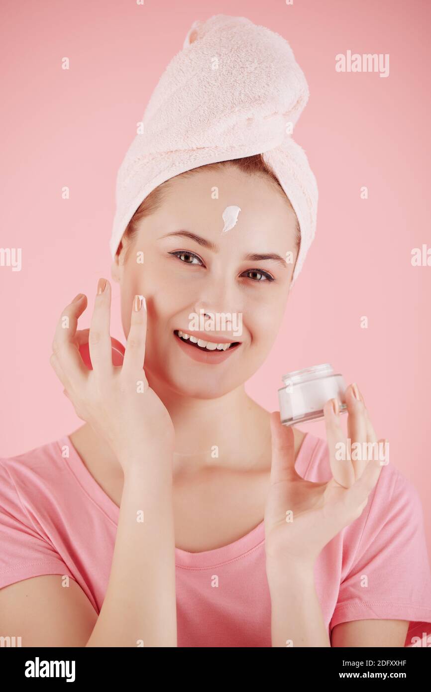 Woman applying nourishing body cream hi-res stock photography and ...