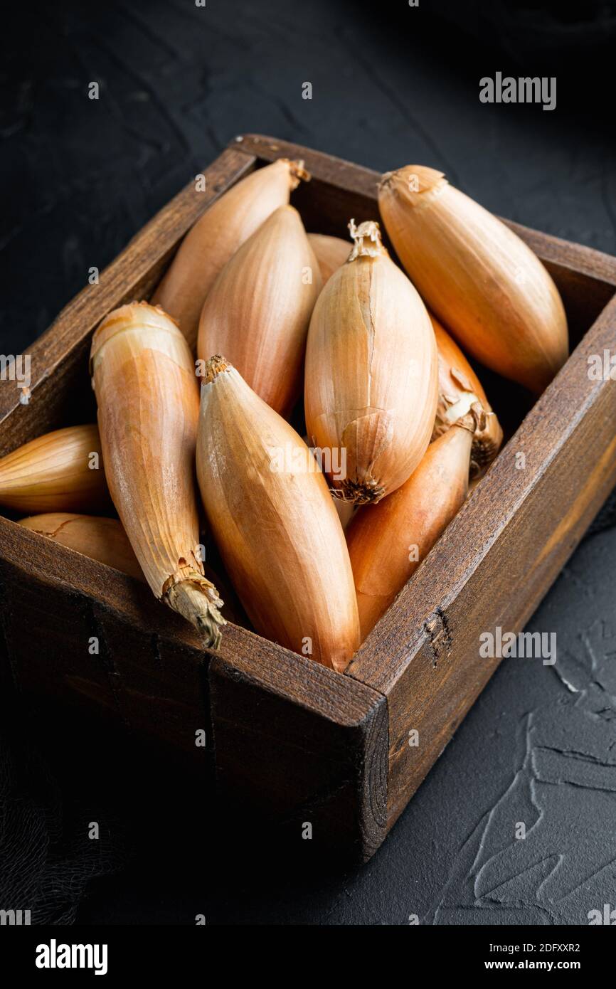 Raw whole baby shallot onion, on black textured background Stock Photo ...