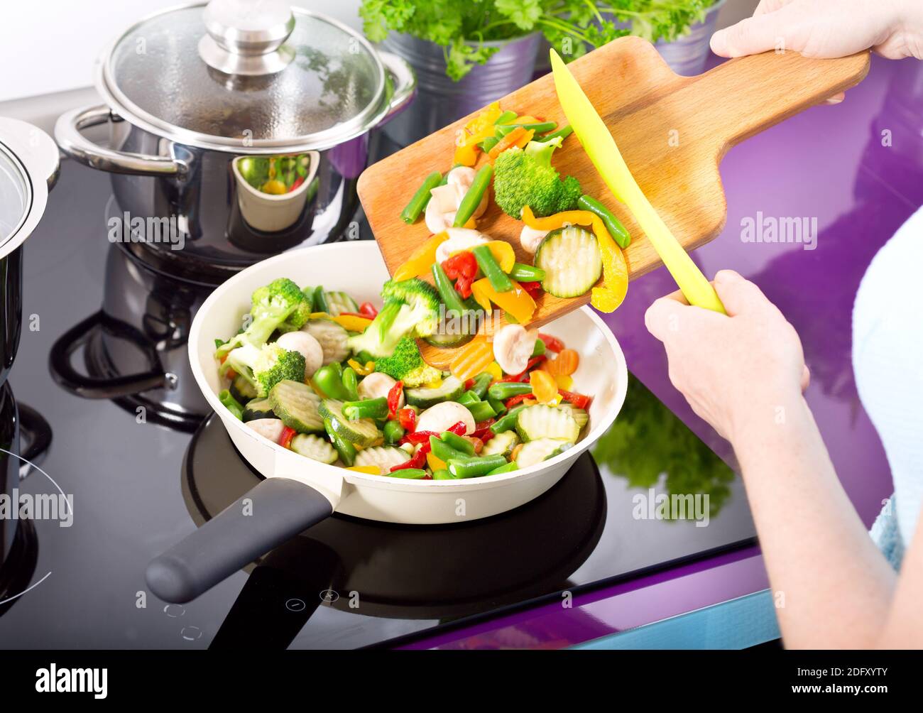 Cooking. Woman prepare fried vegetables in the kitchen Stock Photo - Alamy