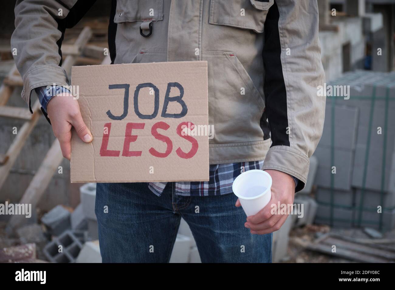 Construction worker stands with placard Jobless opposite construction ...