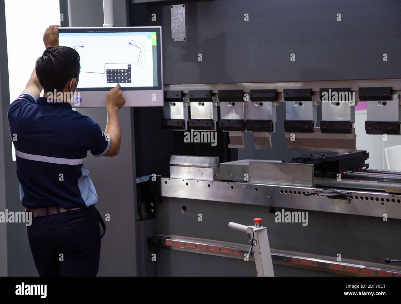 Industrial technician opearting CNC synchronize hydraulic press brake ...