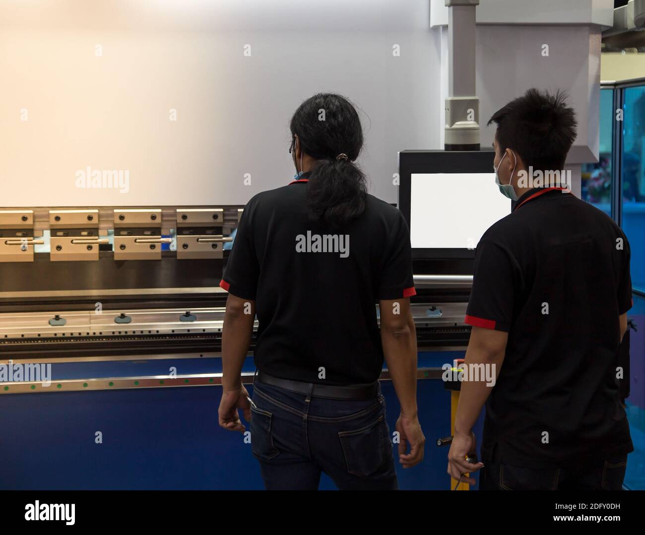 Industrial technician opearting CNC synchronize hydraulic press brake ...