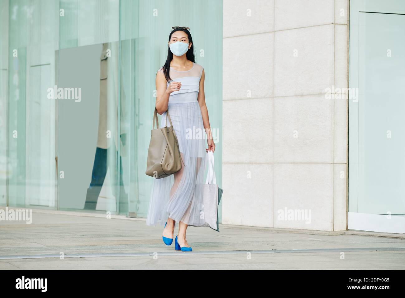 Woman walking down empty street Stock Photo - Alamy