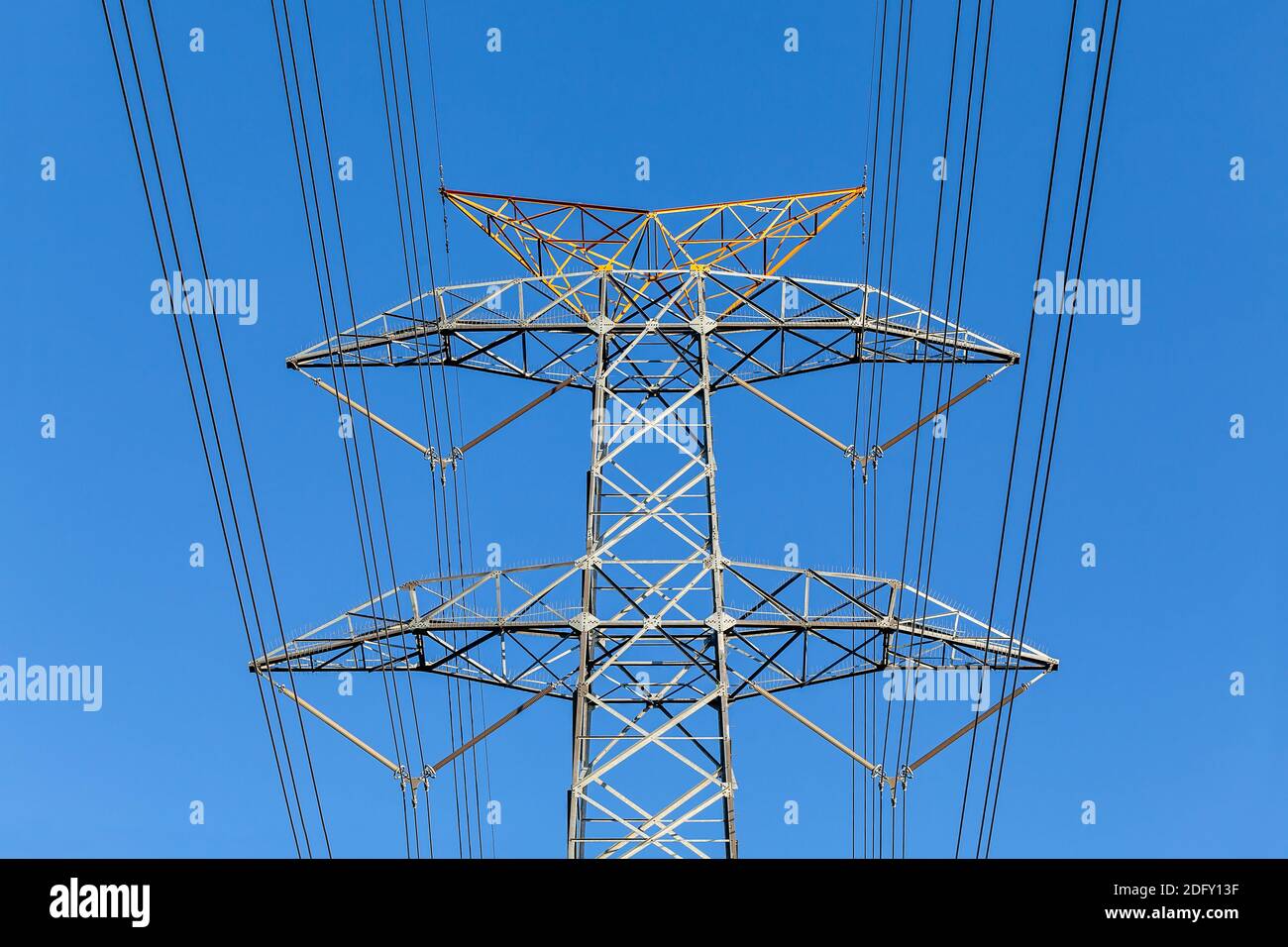 Electricity pylons and overhead cables under blue sky Stock Photo - Alamy