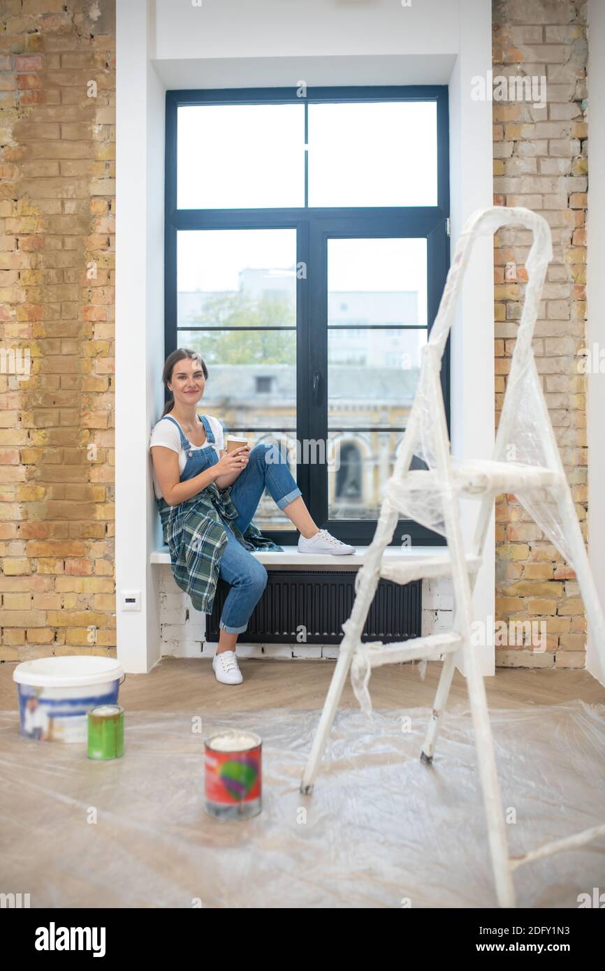 Young woman sitting on the window sill Stock Photo - Alamy