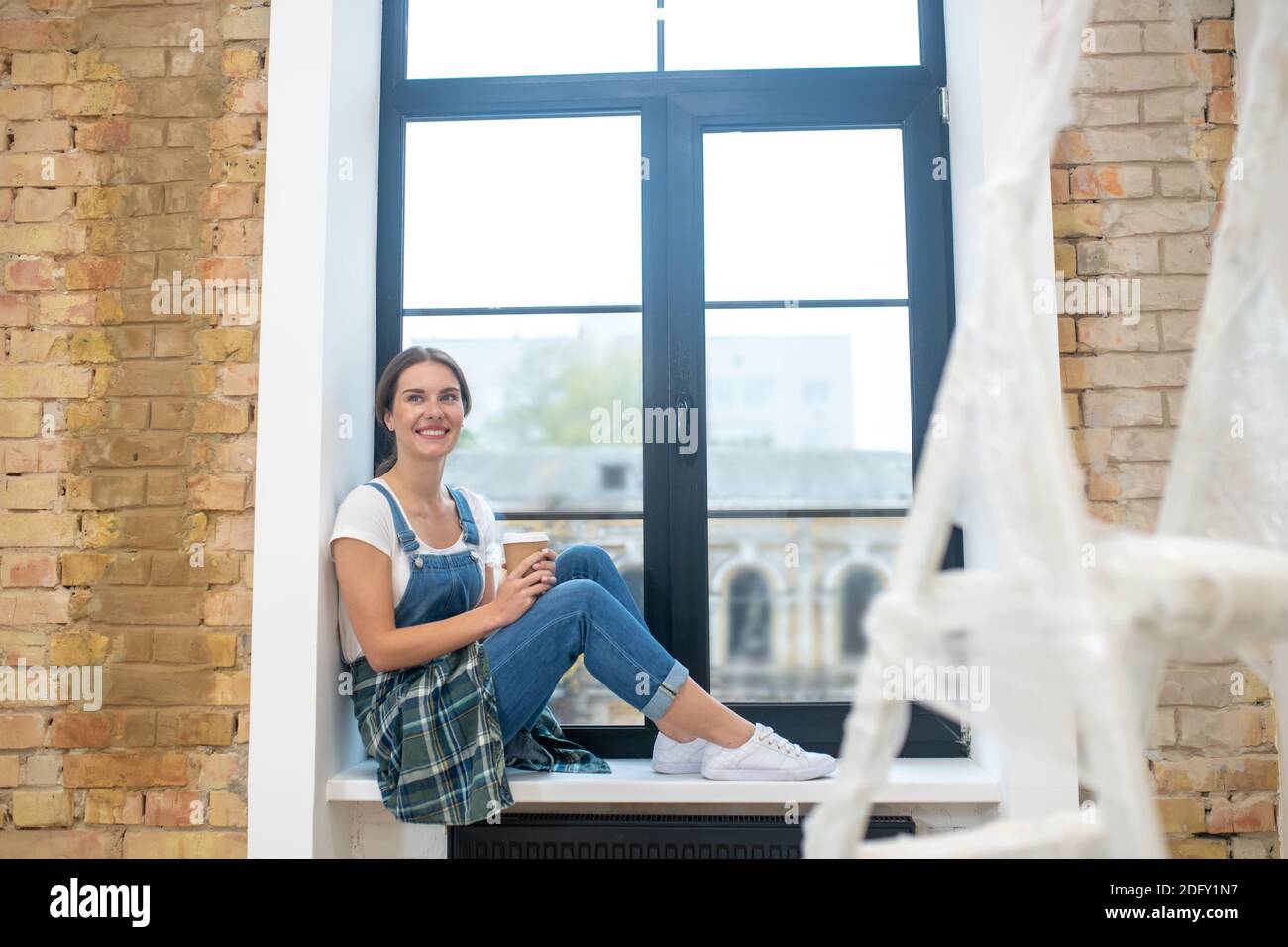 Young woman sitting on the window sill Stock Photo - Alamy