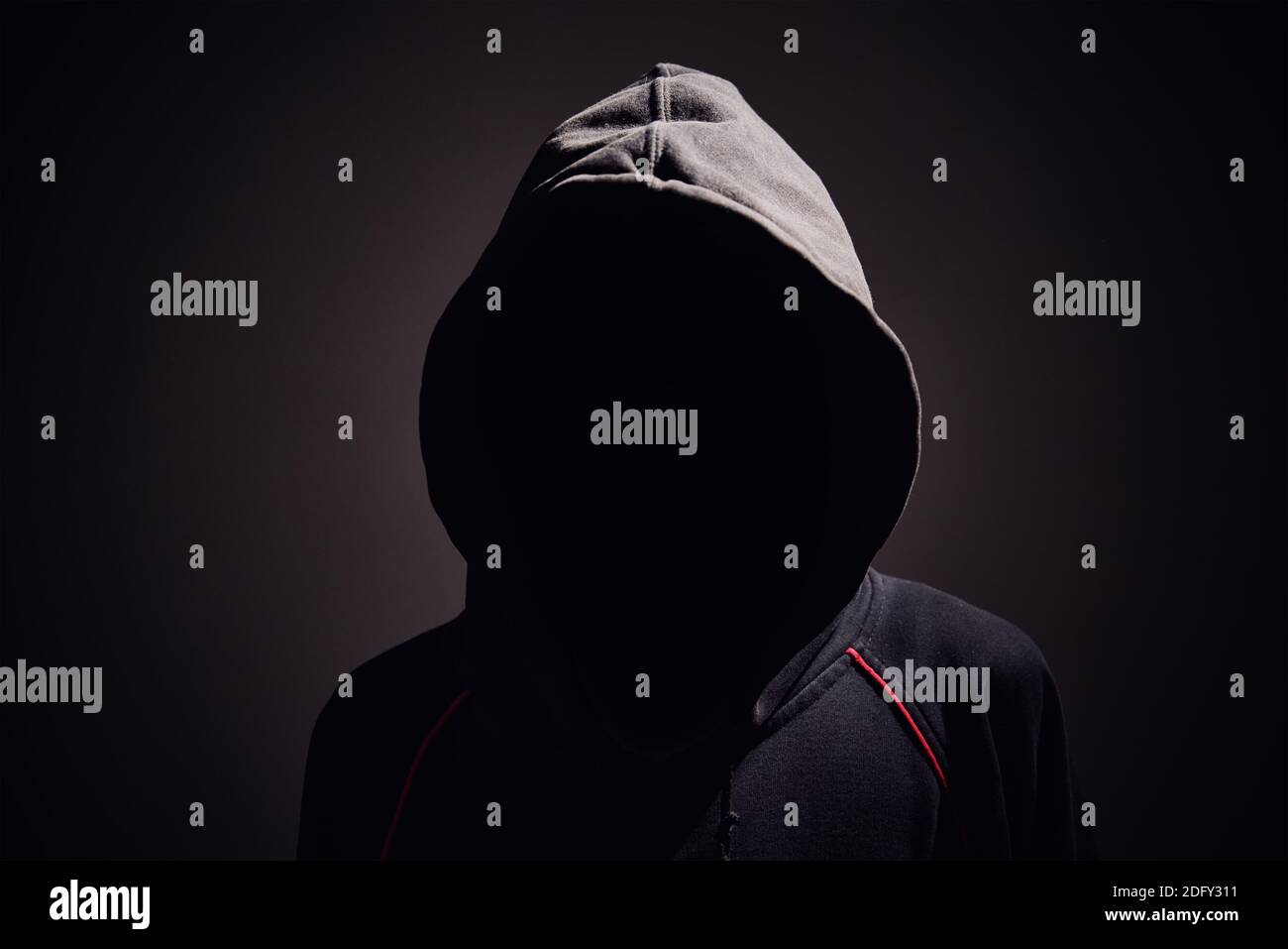 Silhouette af man without face in hood on a black background. Anonymous ...