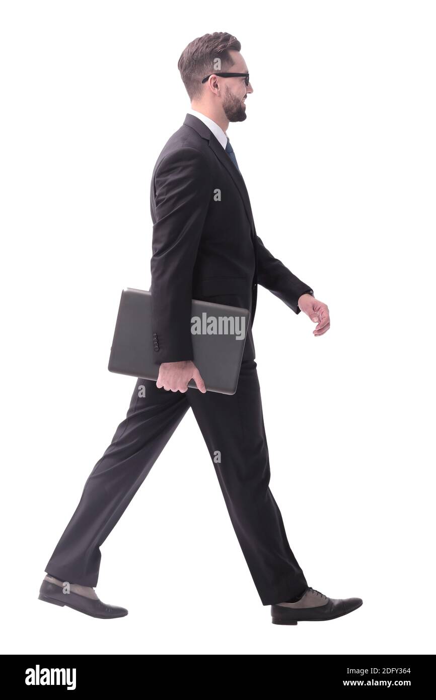 in full growth. successful businessman with laptop stepping forward ...