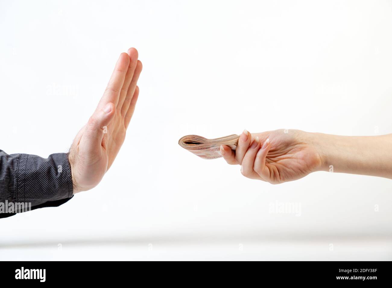Bribery. A female hand gives a bribe, but the male hand in the shirt ...