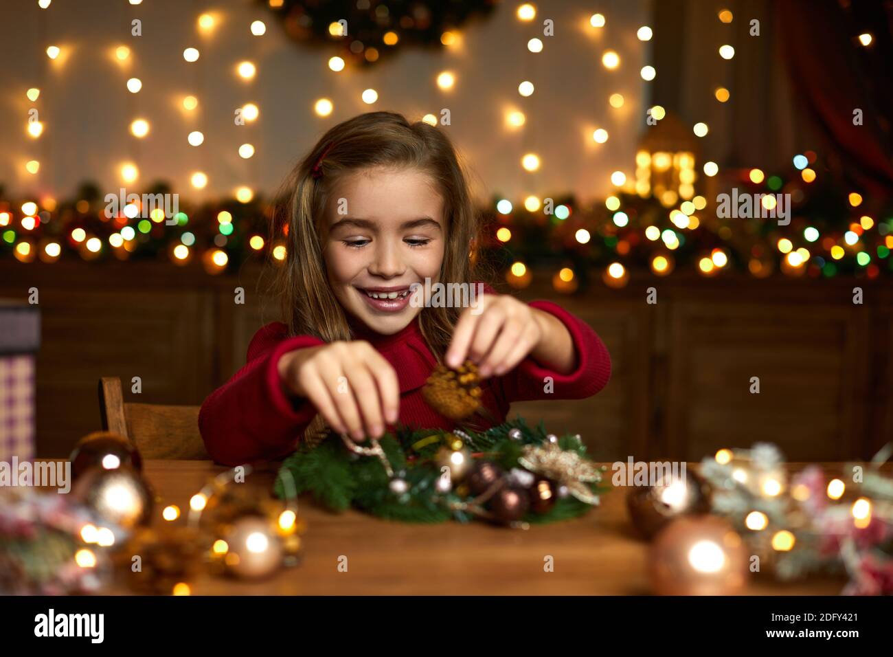 happy cute little child girl decorating Christmas wreath at home Stock ...