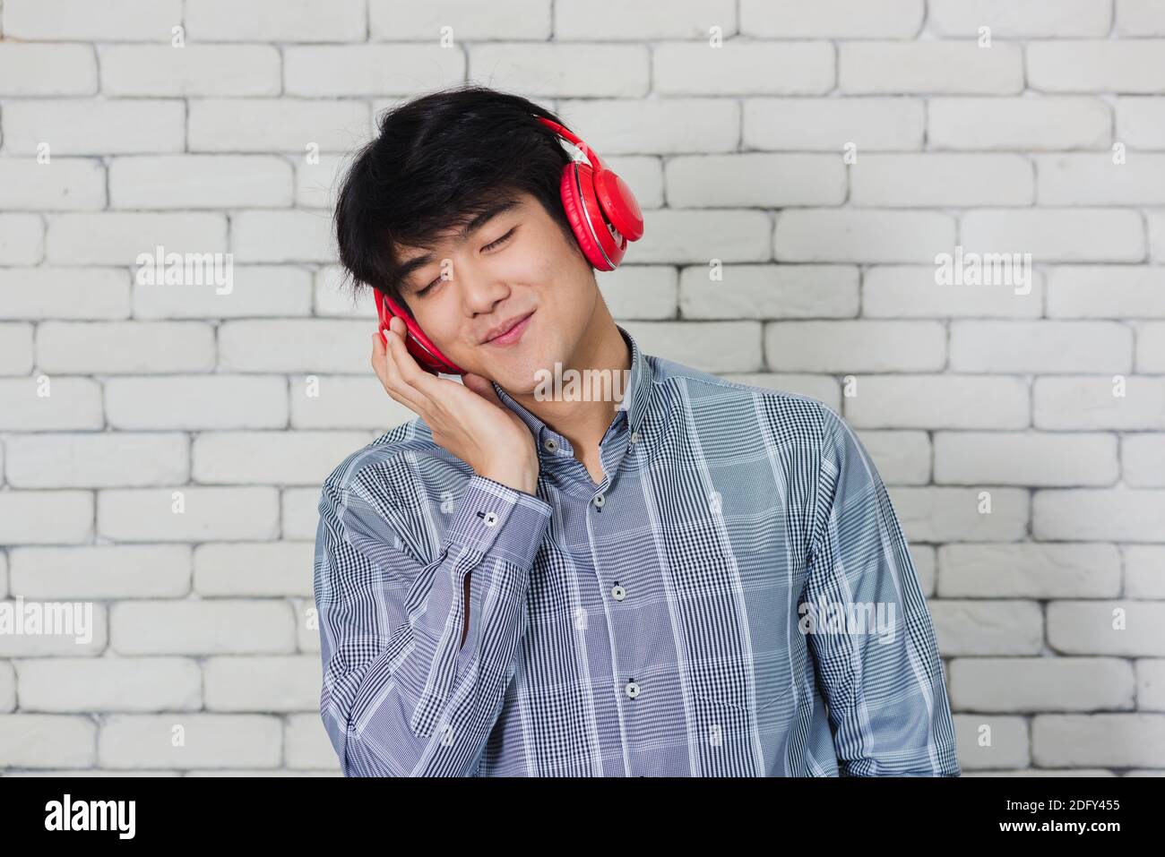 Portrait of Asian handsome young man he smile listening to music in ...