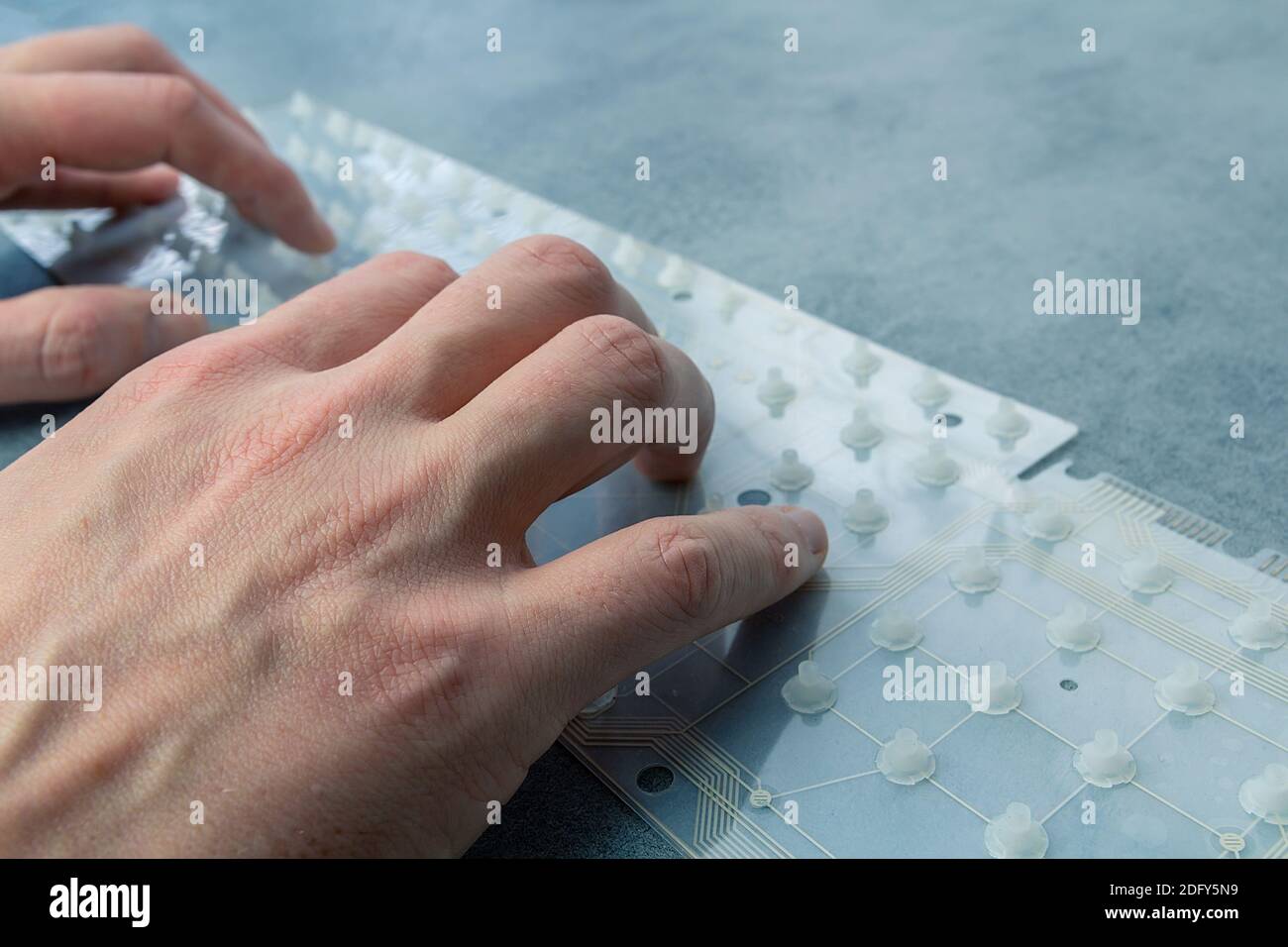Man hand typing on modern slim futuristic keyboard on desk Stock Photo ...