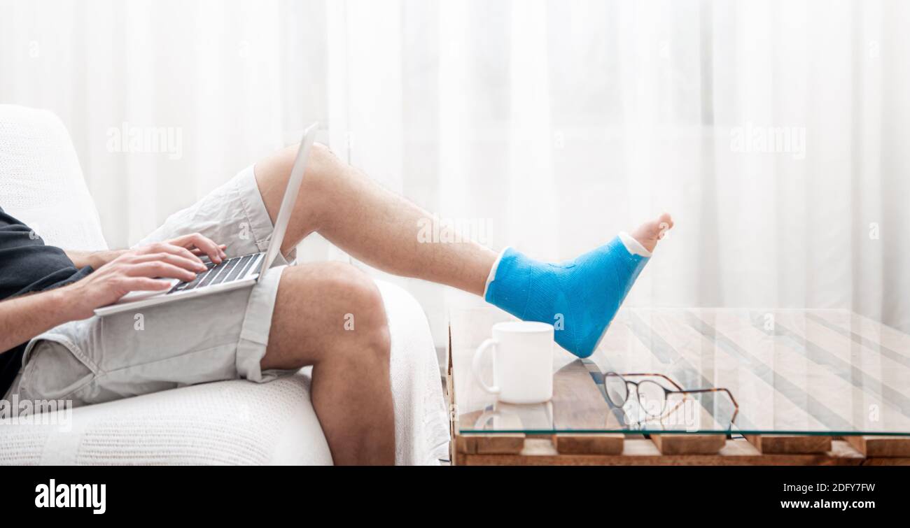 Man with a broken leg in blue splint for treatment of injurie and ankle ...