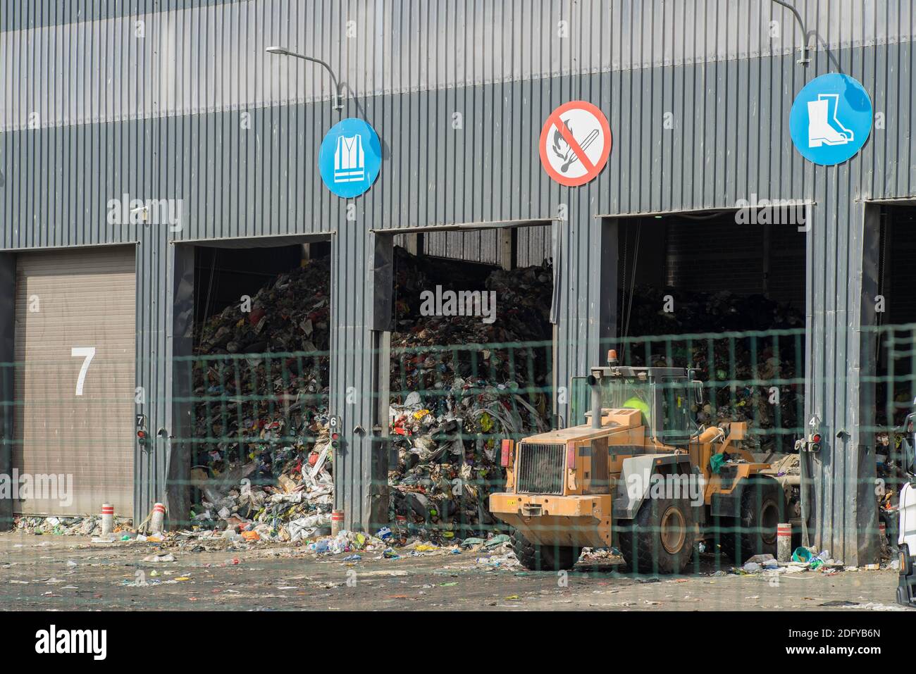 Huge industrial warehouse of household waste. Dump of big city. Yellow ...