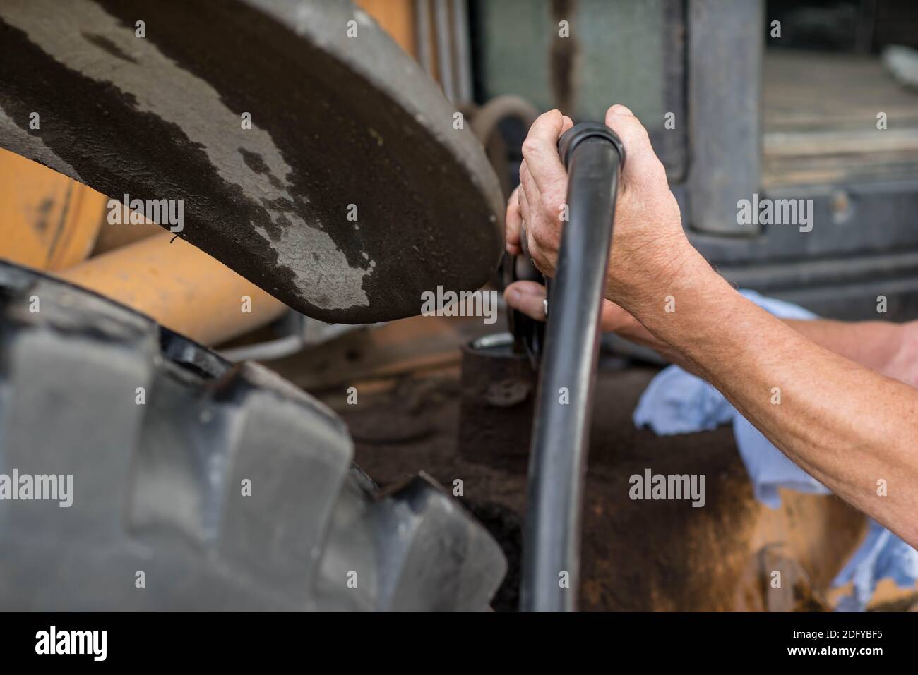 Man refueling tractor at the gas station. Pumping petrol with fuel pump ...