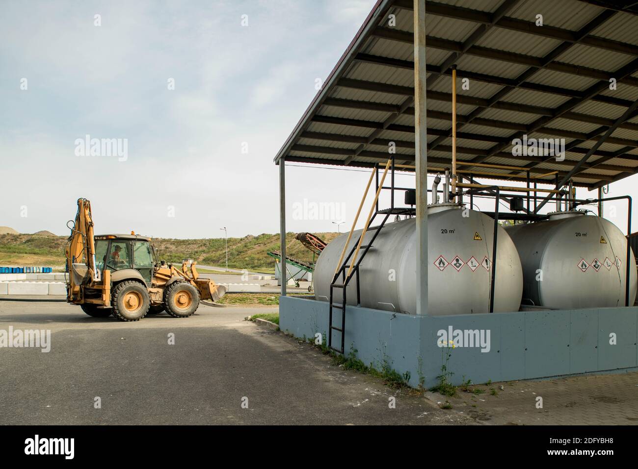 Yellow tractor on gas station. Heavy equipment. Tanks with fuel Stock ...