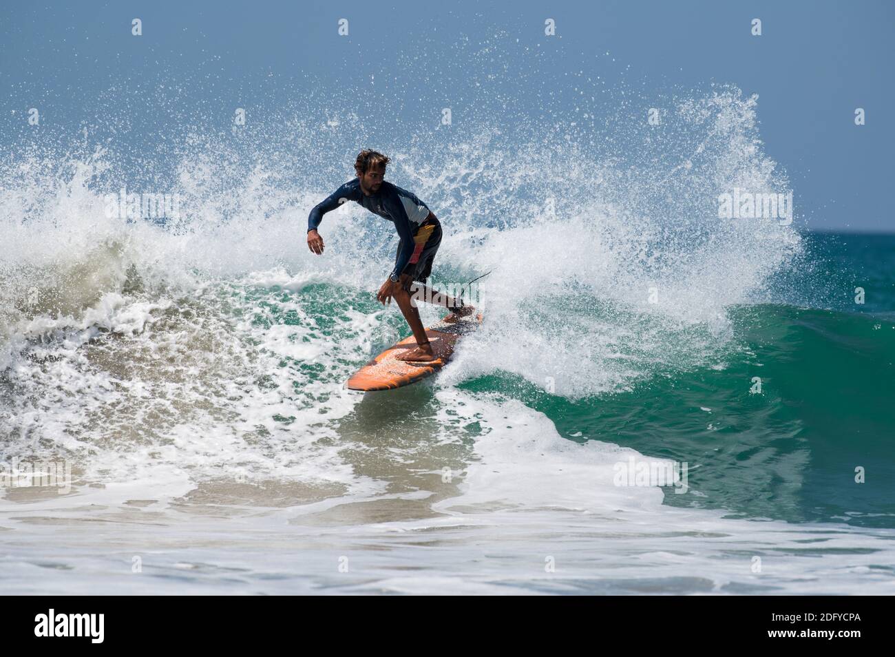 VARKALA, INDIA - Mar 14, 2020: An Indian Male Surfer on his Surf Board ...