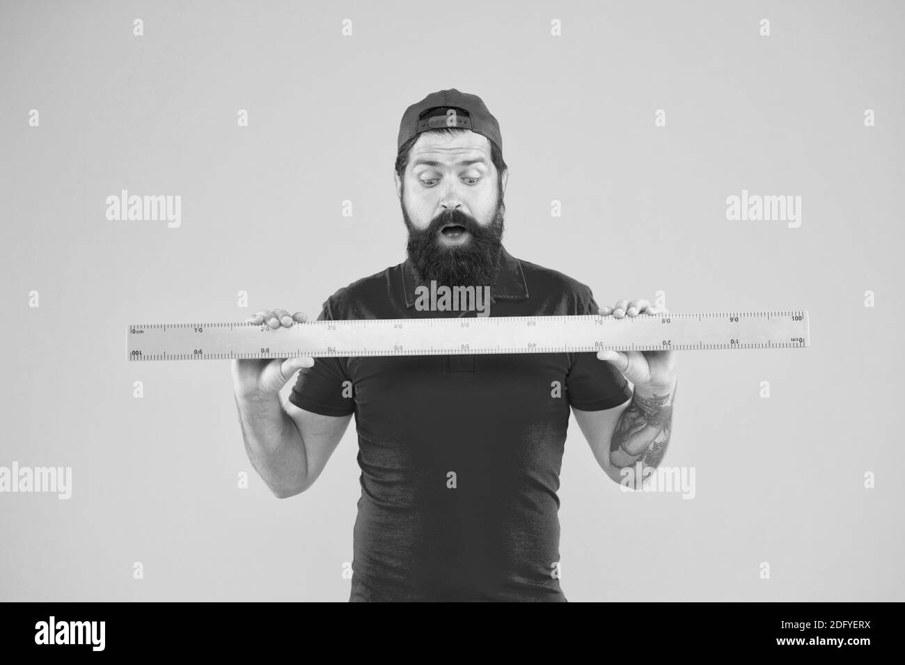 Big size. Measuring tool. Man holding ruler on yellow background ...