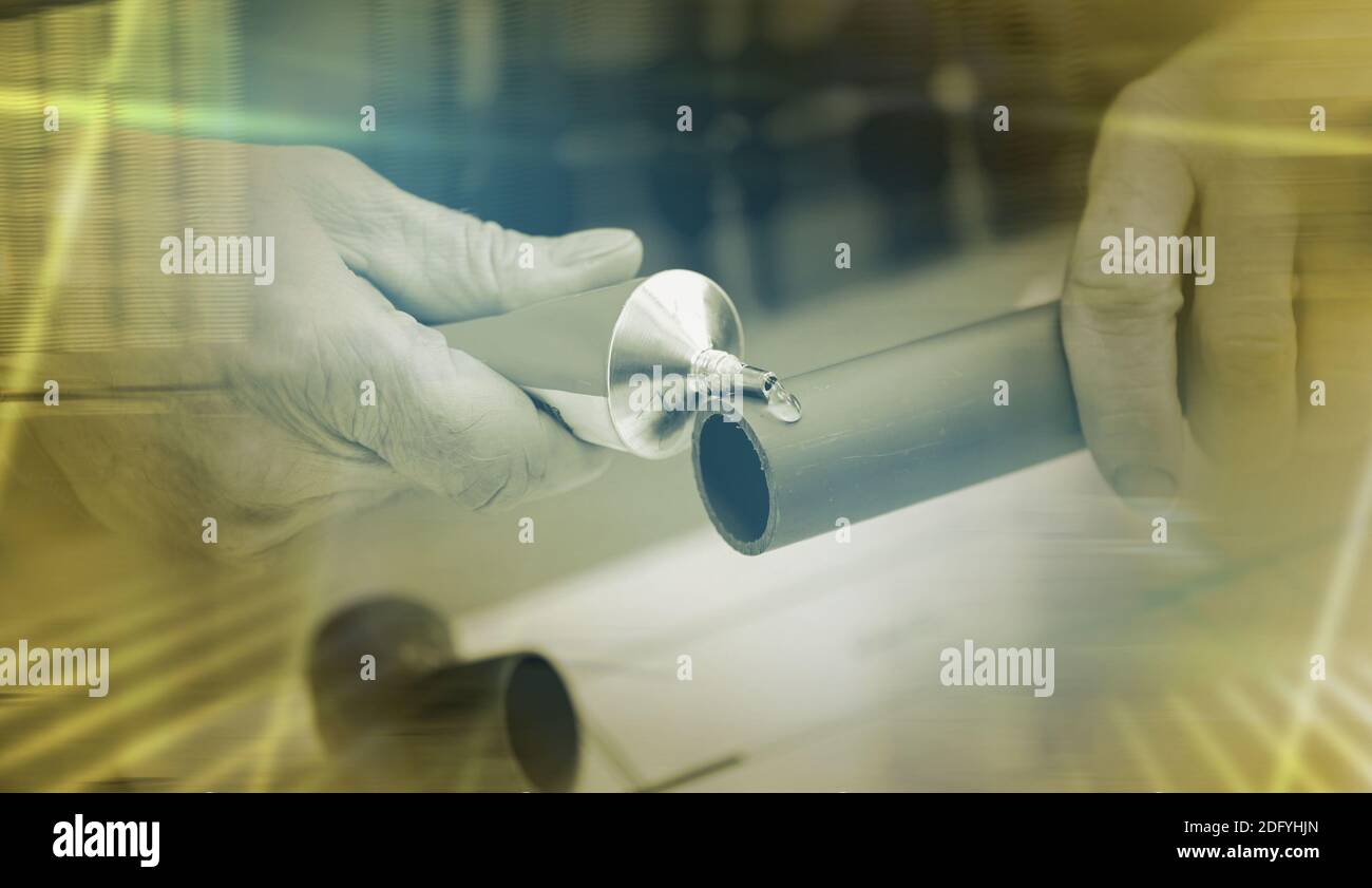 Plumber putting glue on a pvc pipe; light effect Stock Photo - Alamy