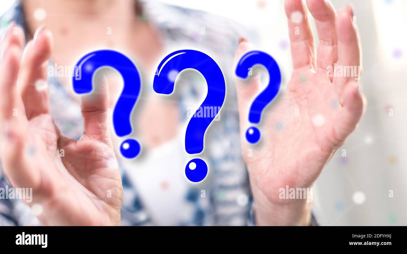 Question concept between hands of a woman in background Stock Photo - Alamy