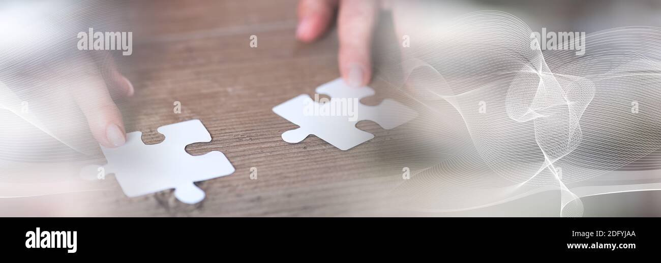 Hands joining two puzzle pieces, teamwork concept; panoramic banner ...