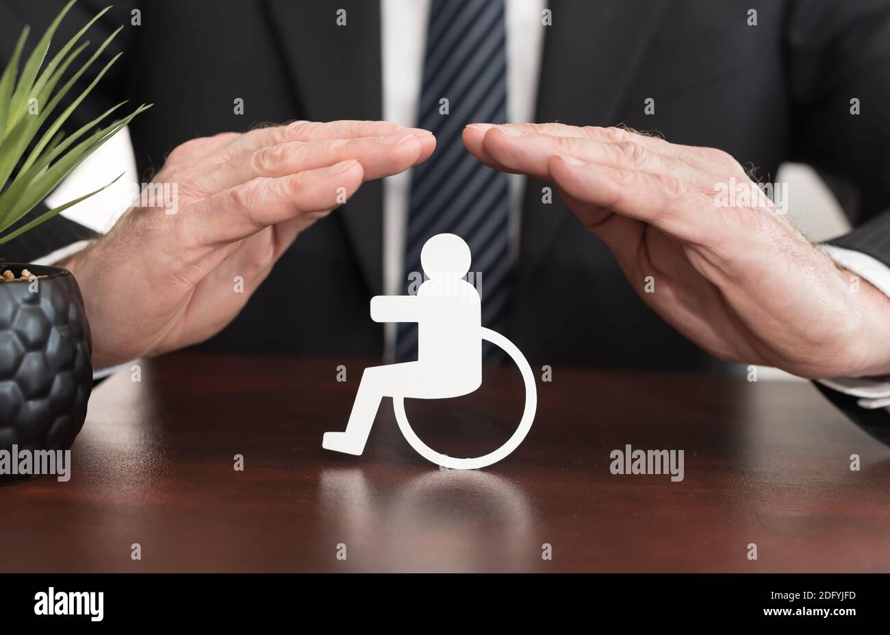 Insurer protecting a disabled person with his hands Stock Photo - Alamy