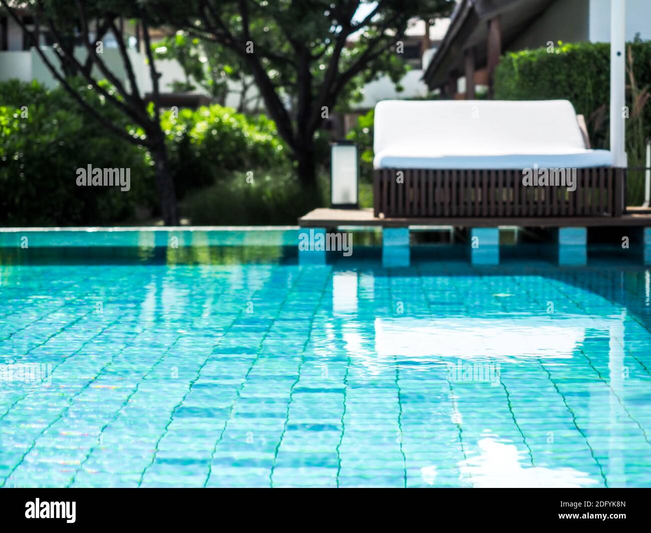 Blurred view of pool with white sunbed in the resort. Blurred of clean ...