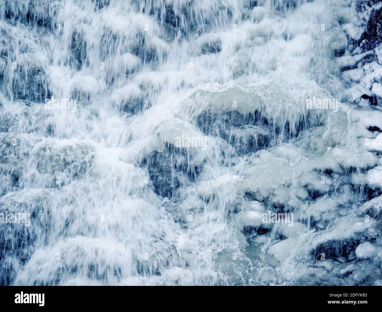 Water in motion. Cascades of the waterfall in winter close-up. Frozen ...