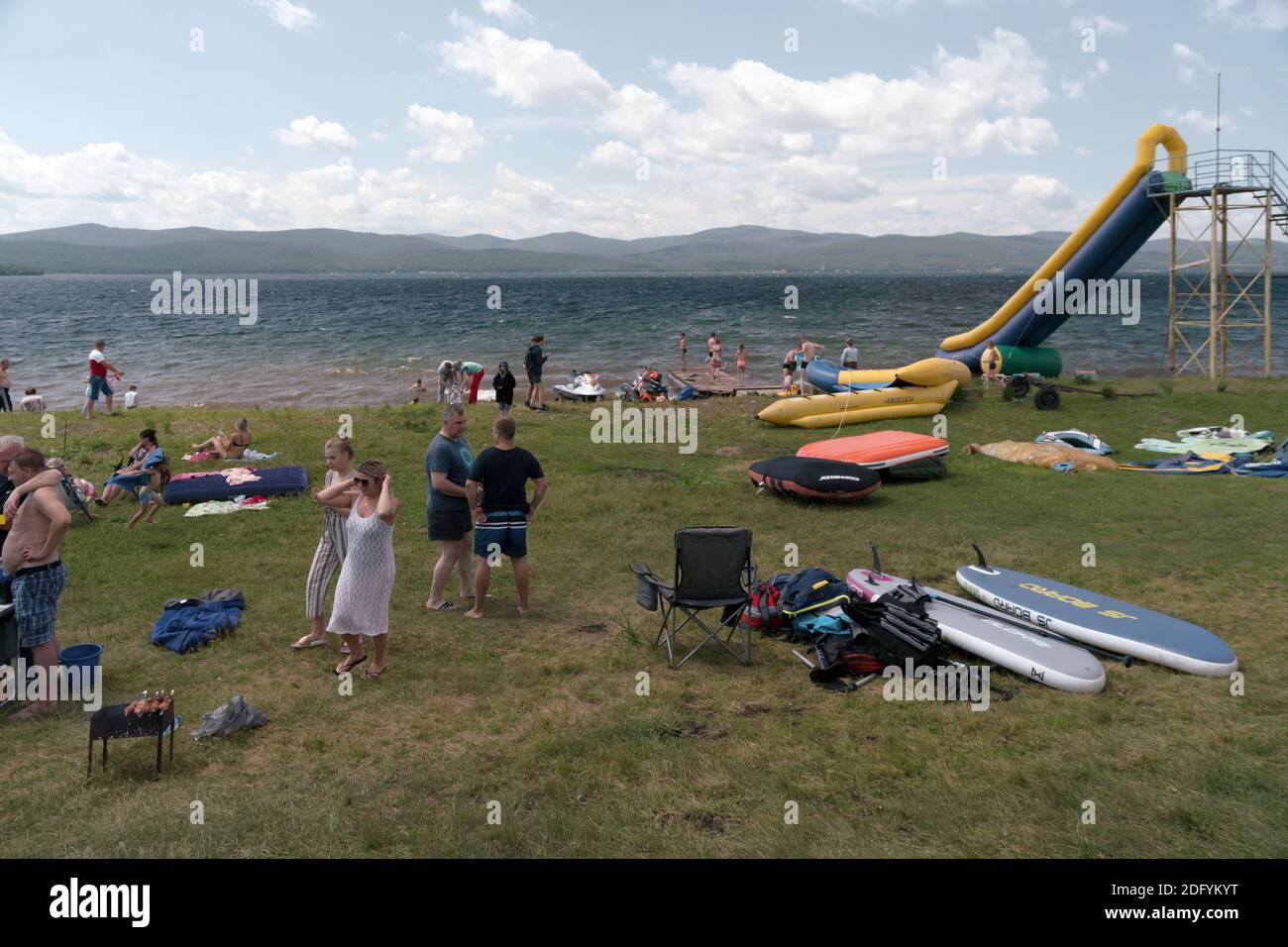 A large group of people are resting on the shore of the Big Lake during ...