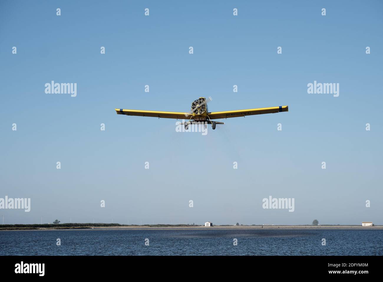 A single-engine propeller airplane flying in a perfectly clear blue sky ...