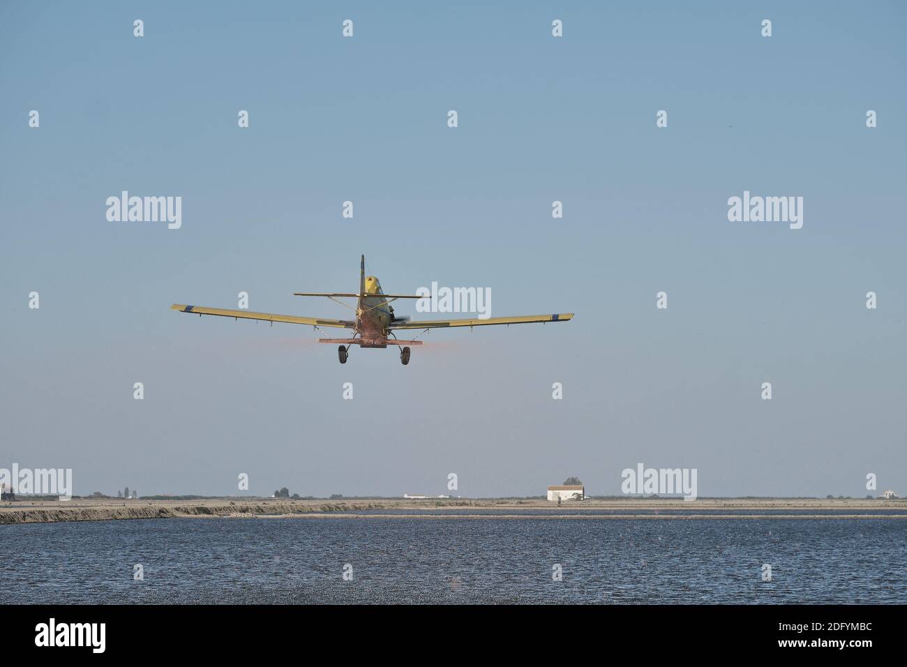 A single-engine propeller airplane flying in a perfectly clear blue sky ...
