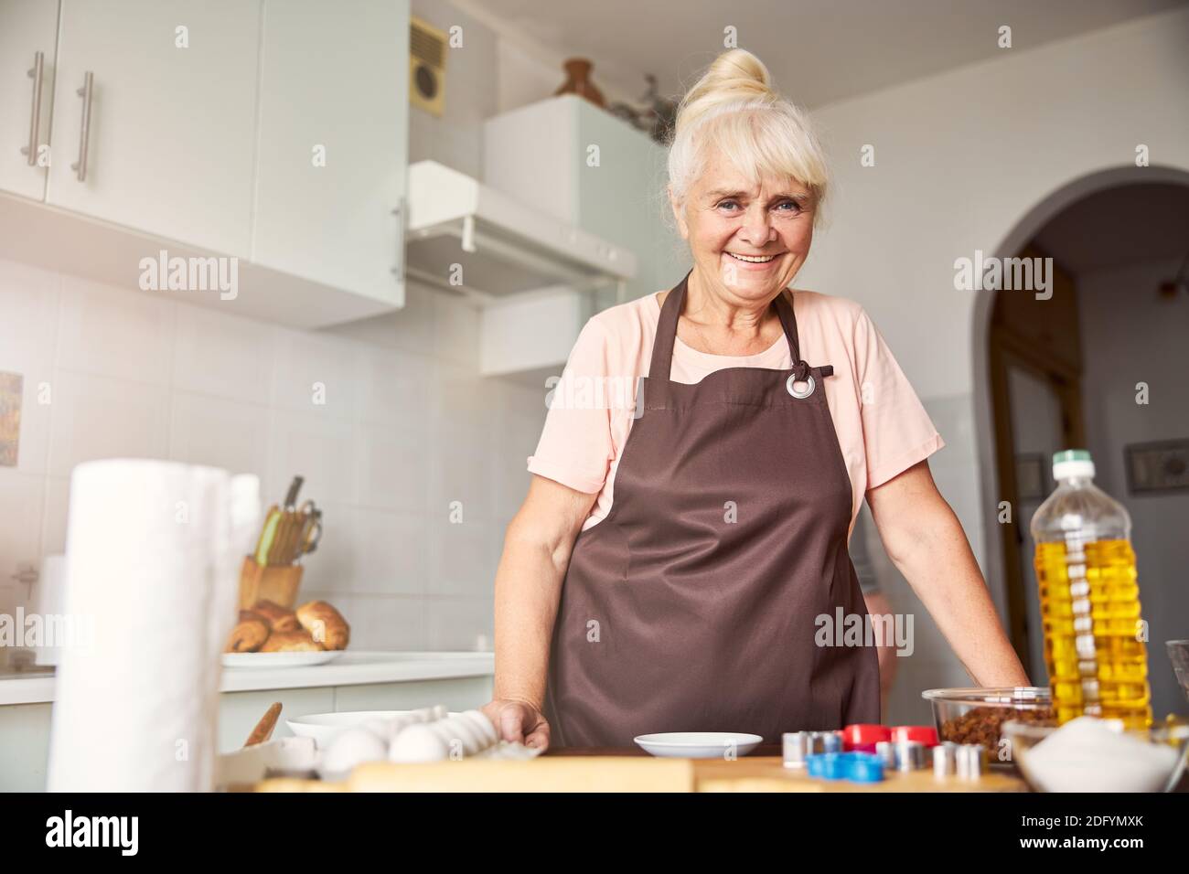 Friendly senior woman smiling in her kitchen Stock Photo - Alamy