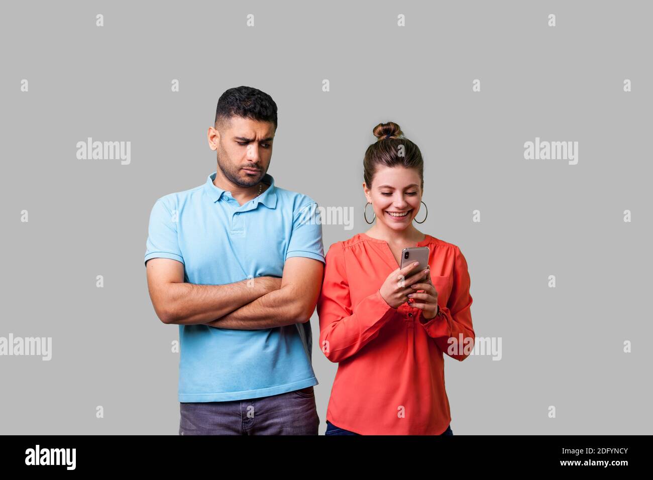Portrait of jealous boyfriend standing with crossed arms, looking ...