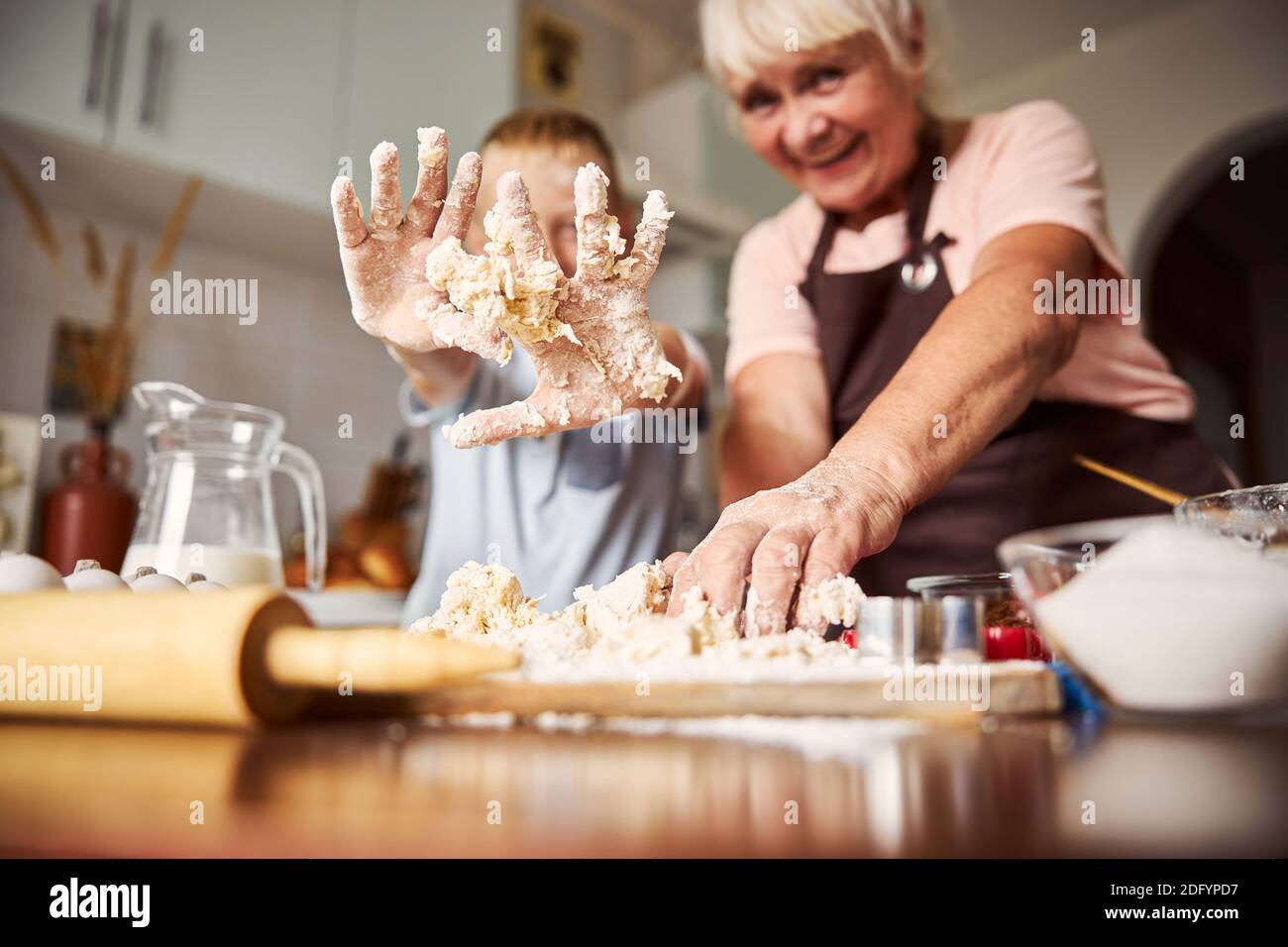 Kid having fun with making dough while cooking with grandma Stock Photo ...