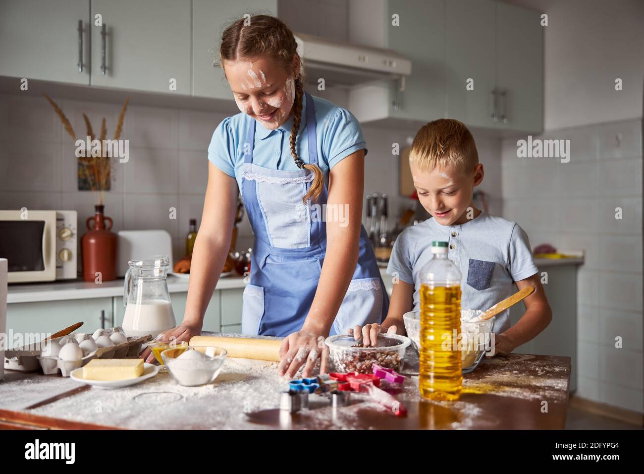 Two jolly siblings experimenting with dough in the kitchen Stock Photo ...