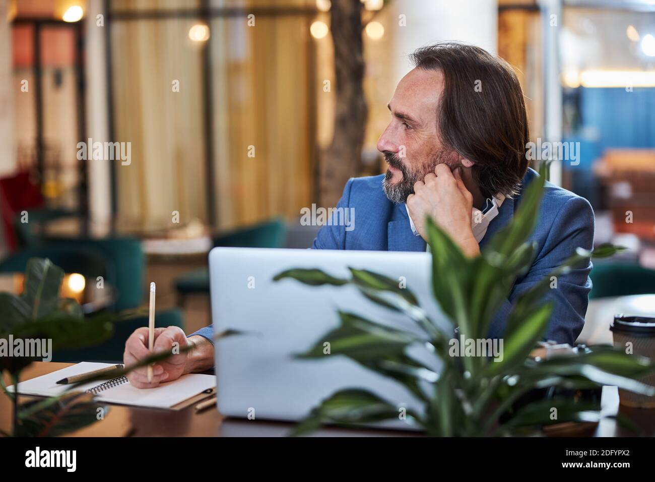 Attractive middle-aged man doing his job remotely from hotel Stock ...