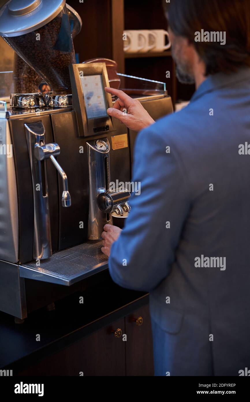 Handsome gentleman getting some coffee from espresso machine Stock ...