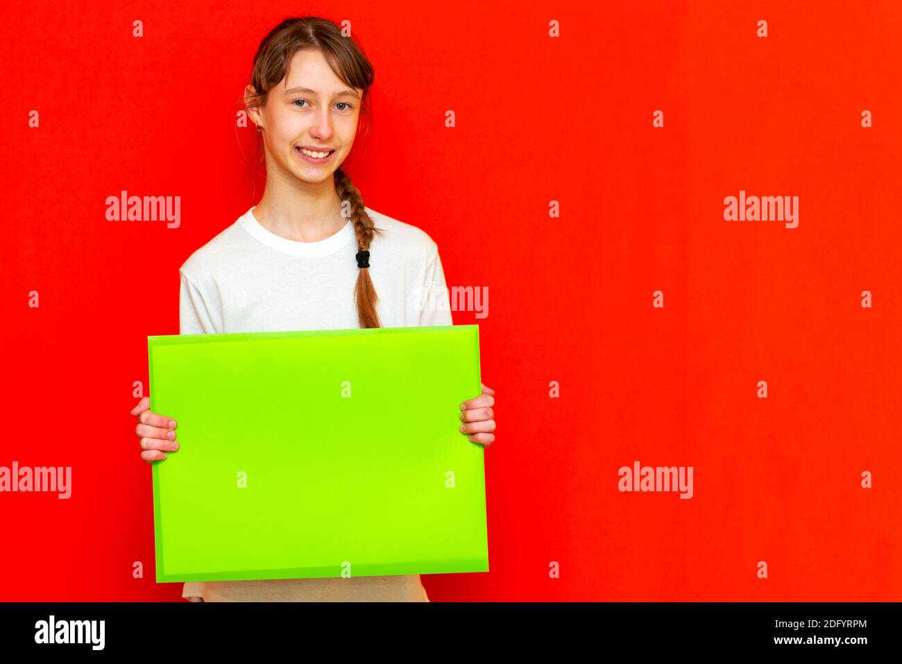 teenager girl showing blank paper.Mock up,banner,copy space.Bright red ...