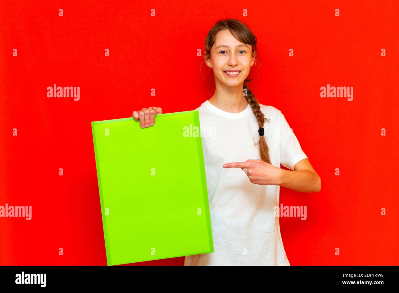 teenager girl showing blank paper.Mock up,banner,copy space.Bright red ...