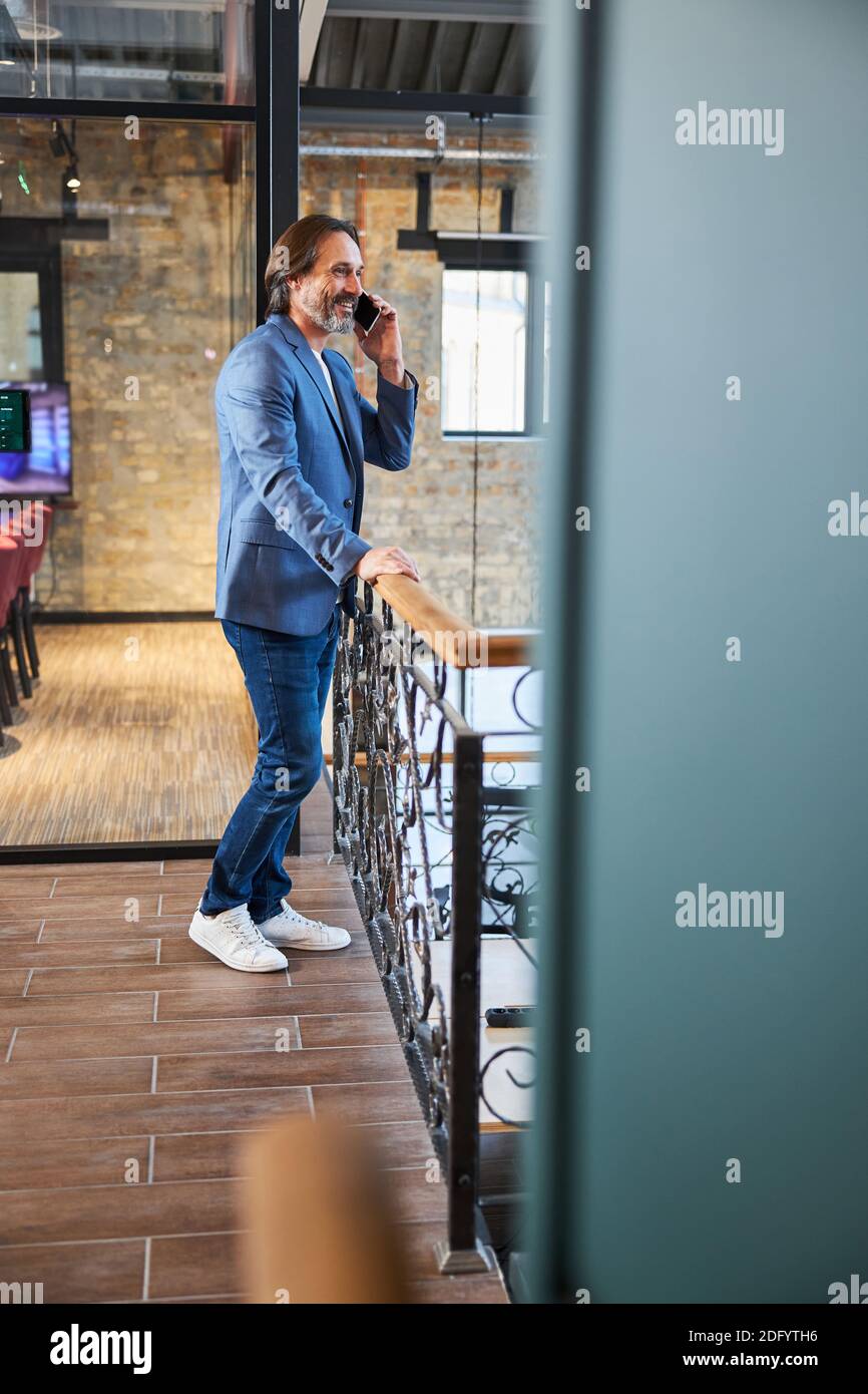Friendly handsome man making a phonecall from hotel lobby Stock Photo ...