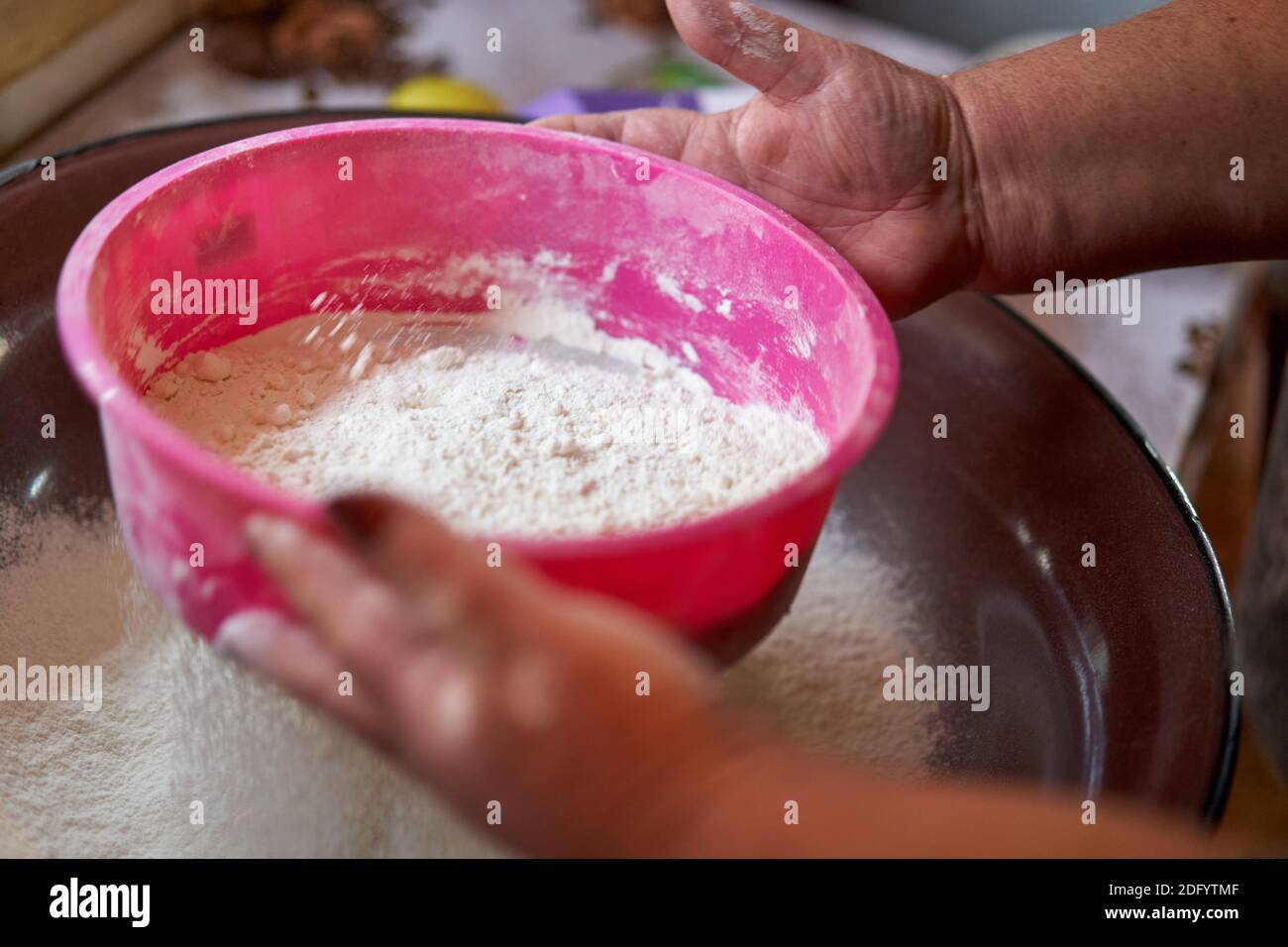 Sifting flour with a sieve closeup in the kitchen Stock Photo - Alamy