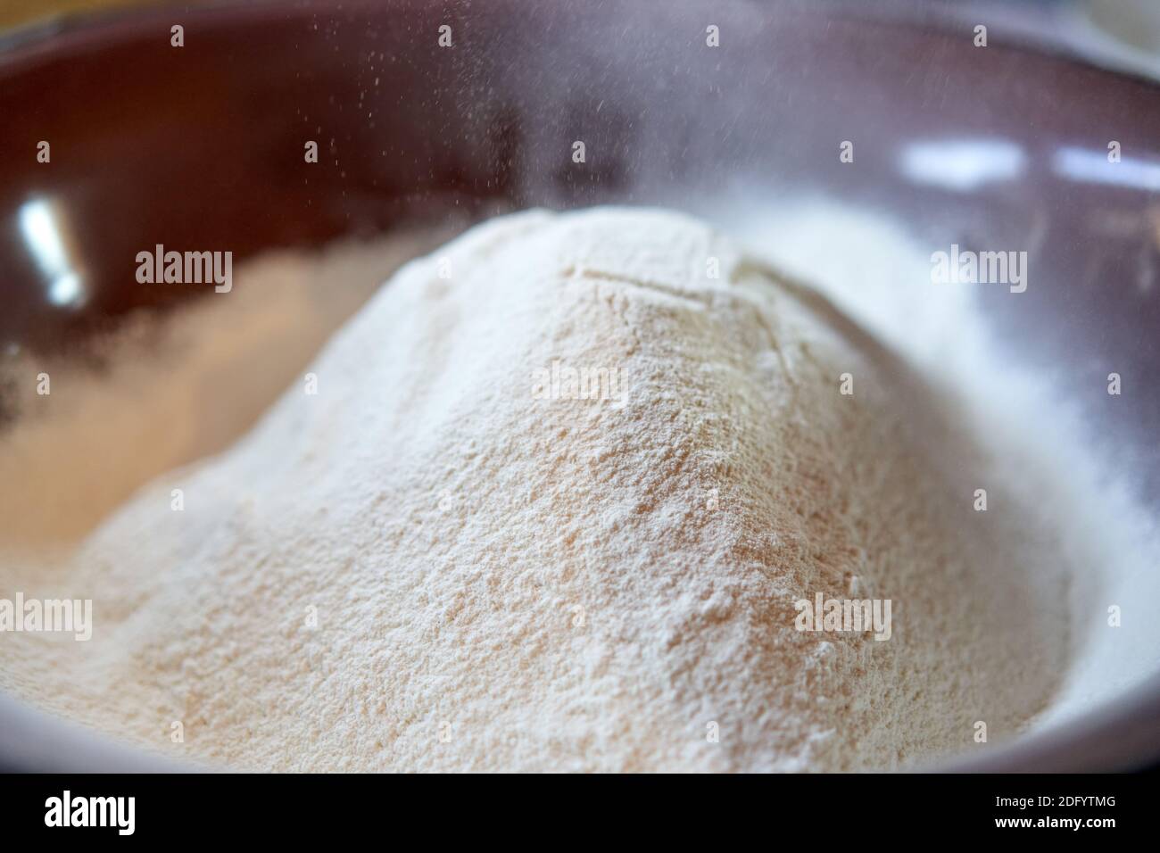 Sifting flour with a sieve closeup in the kitchen Stock Photo - Alamy