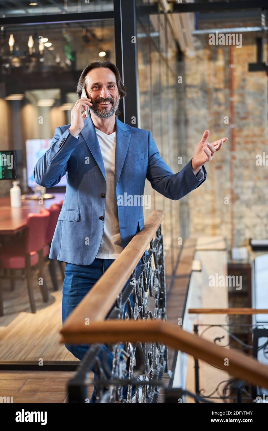 Energetic gentleman having a successful phonecall at hotel Stock Photo ...