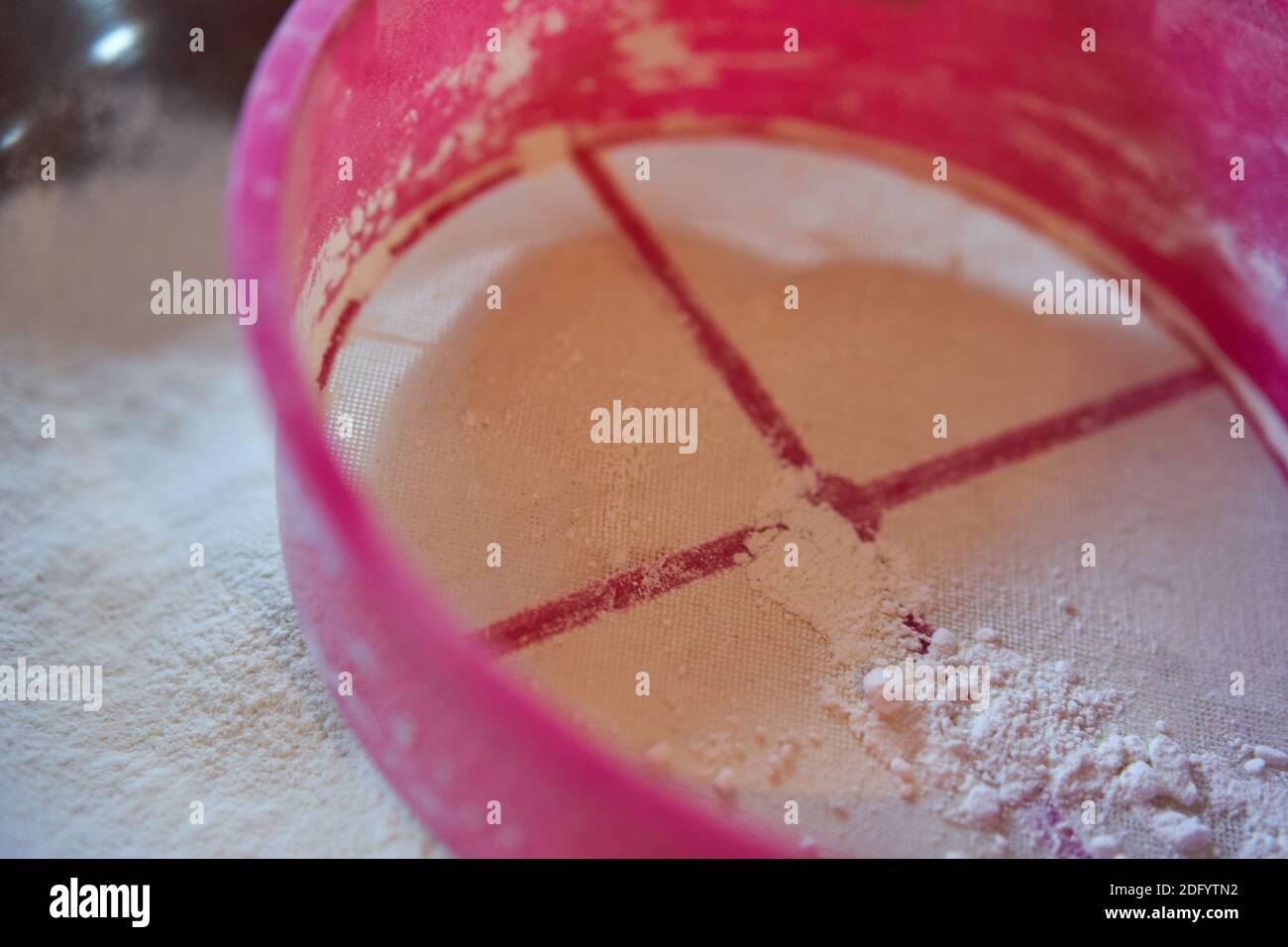 Sifting flour with a sieve closeup in the kitchen Stock Photo - Alamy